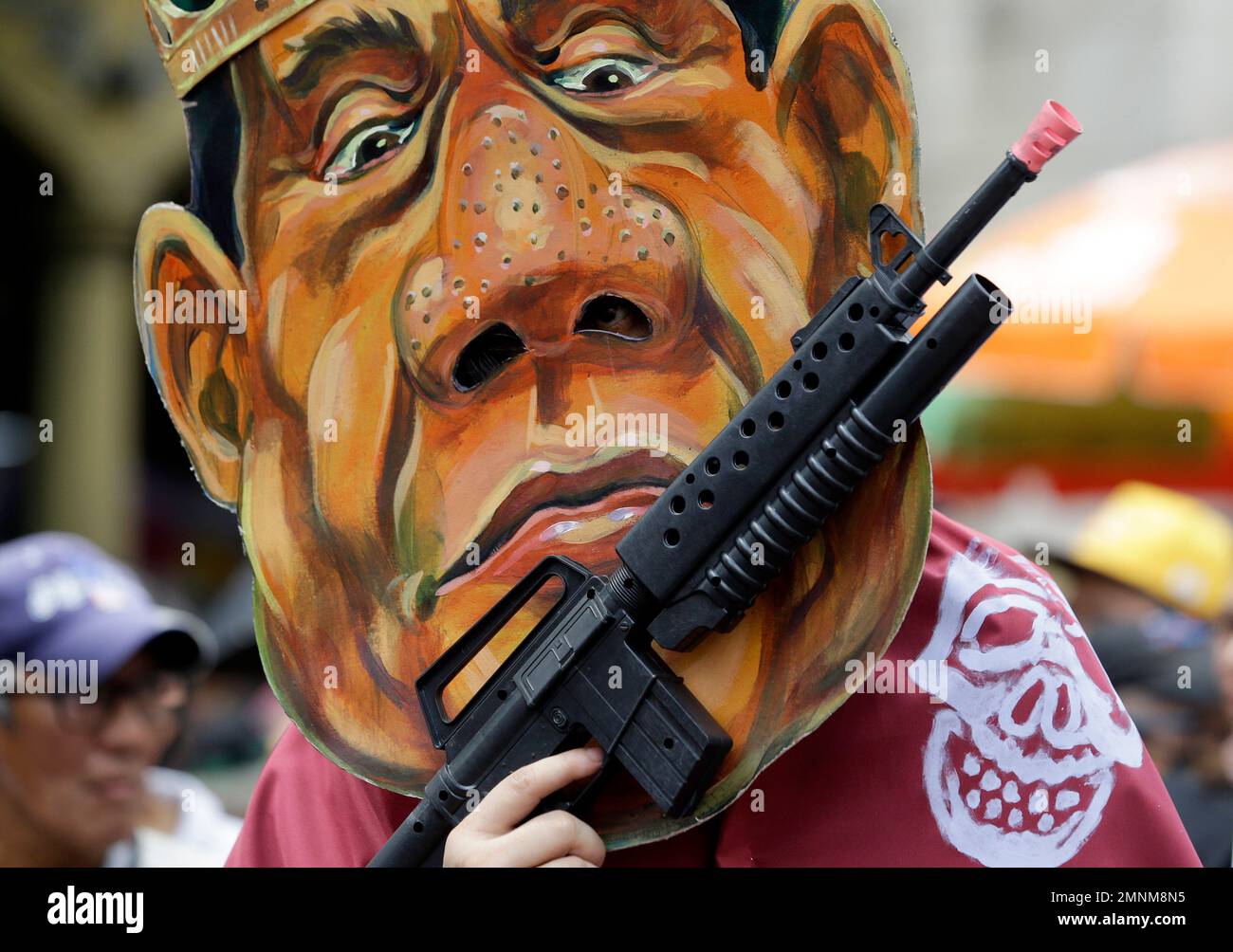 A protester wears a mask showing the face of Philippine President ...