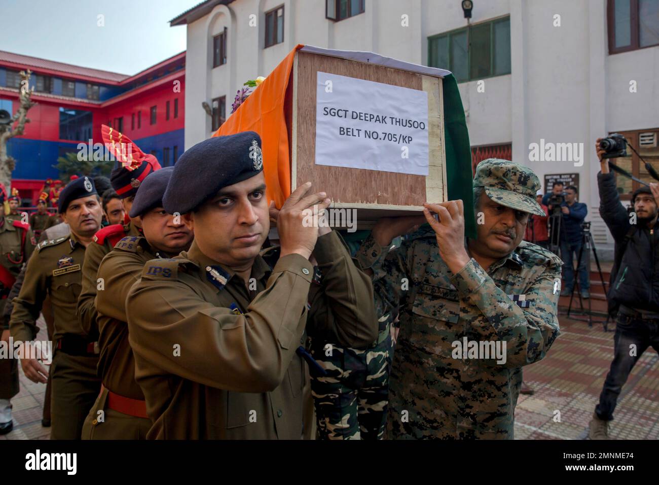 Police and paramilitary officers carry the coffin of their colleague ...