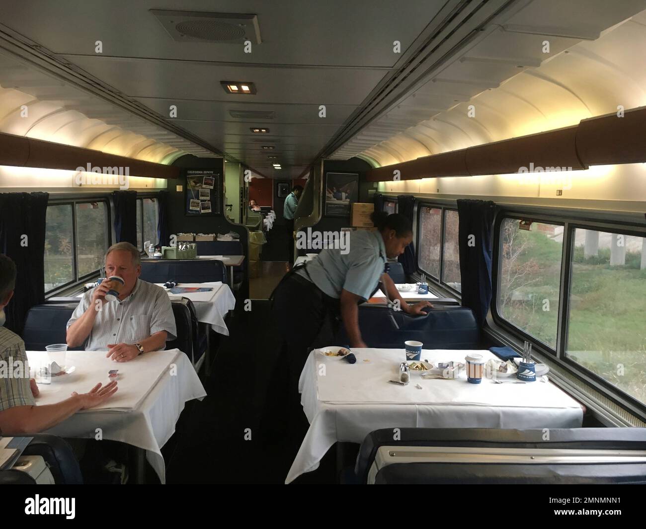 In this Nov. 5, 2017 photo, an Amtrak dining car server buses a table ...