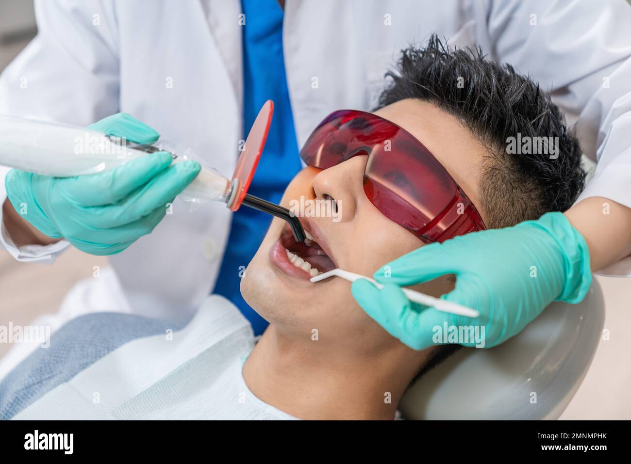 A young man in the dental clinic treatment teeth Stock Photo - Alamy