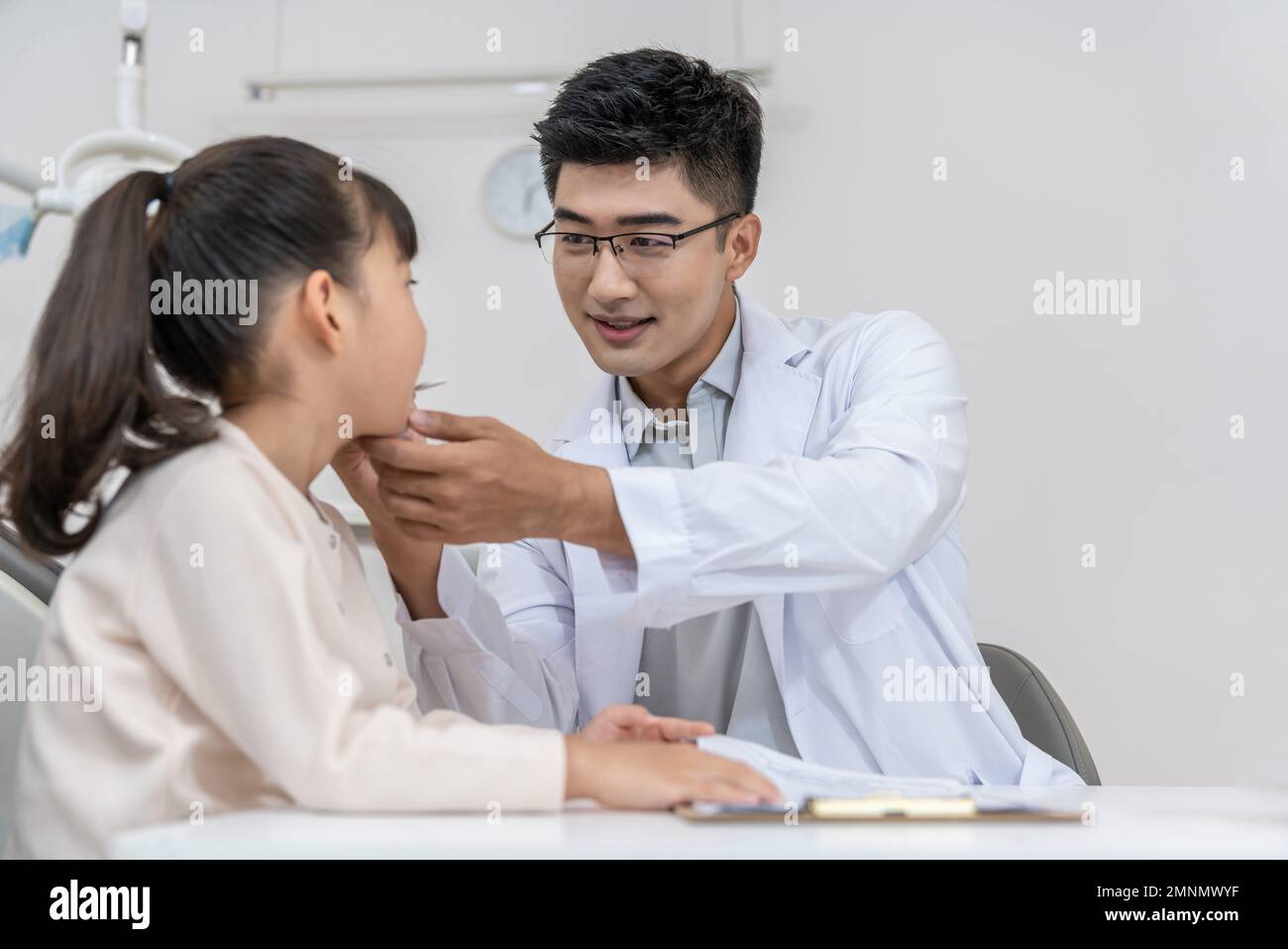 The dentist and check the teeth little girl Stock Photo - Alamy