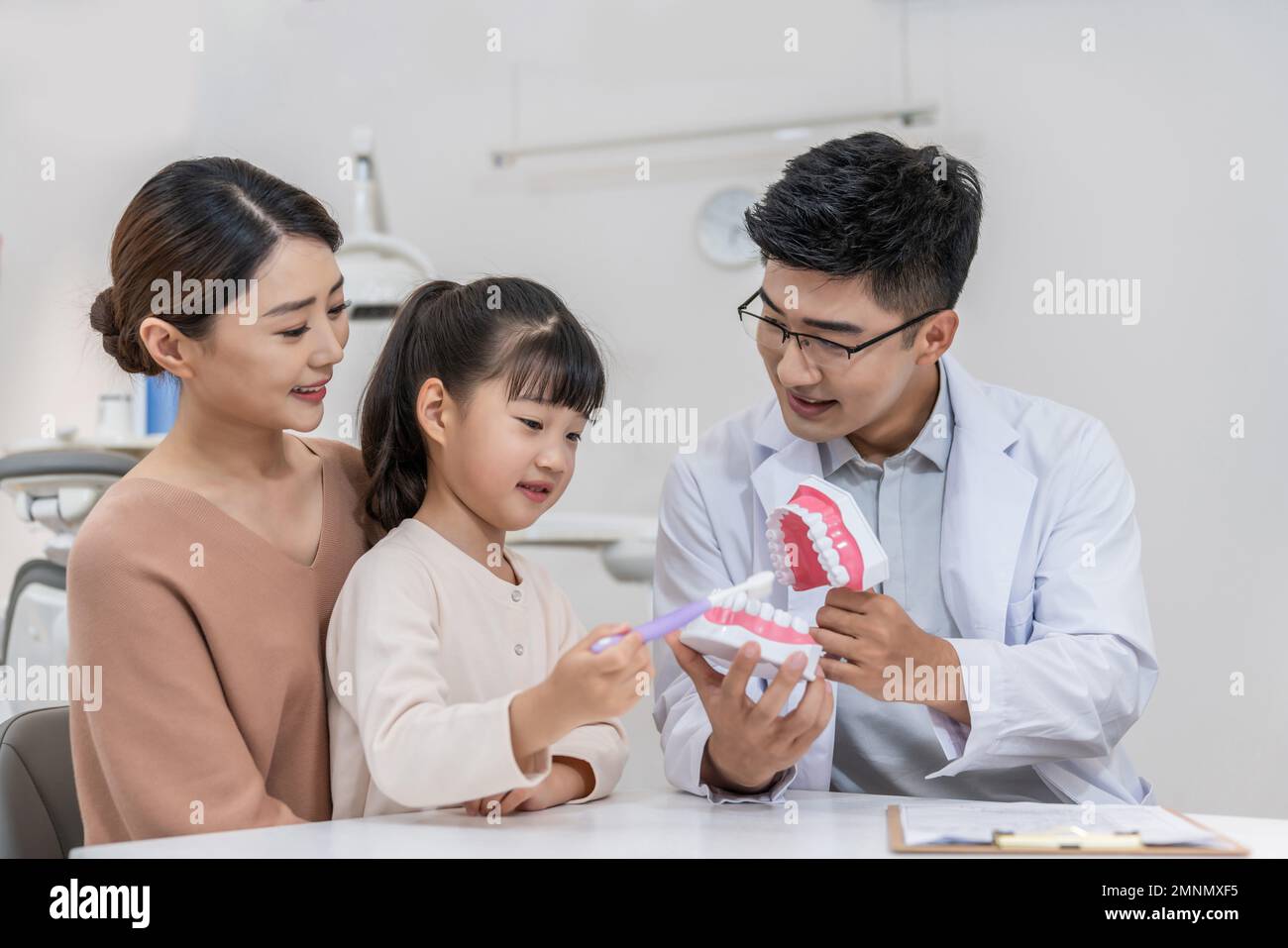 Mother with her two daughters in dental clinic Stock Photo - Alamy
