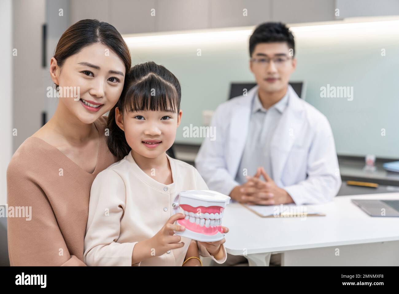 Mother with her two daughters in dental clinic Stock Photo - Alamy