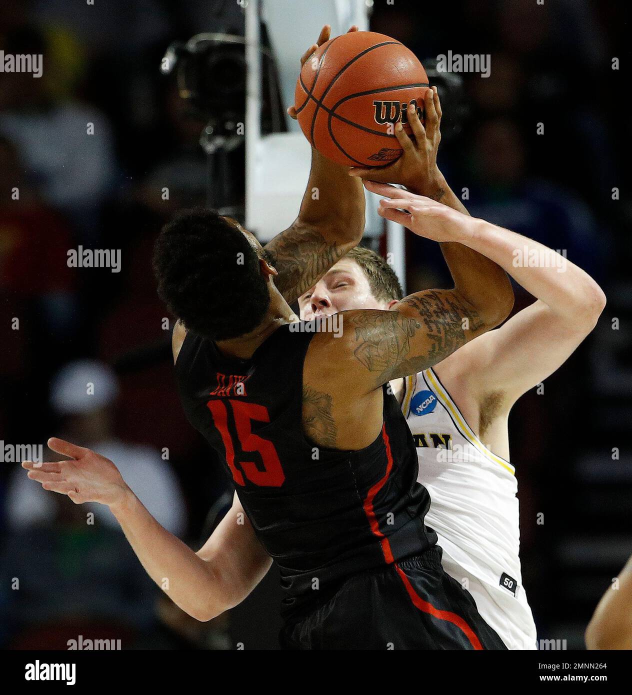 Houston forward Devin Davis (15) tries to shoot over Michigan center ...
