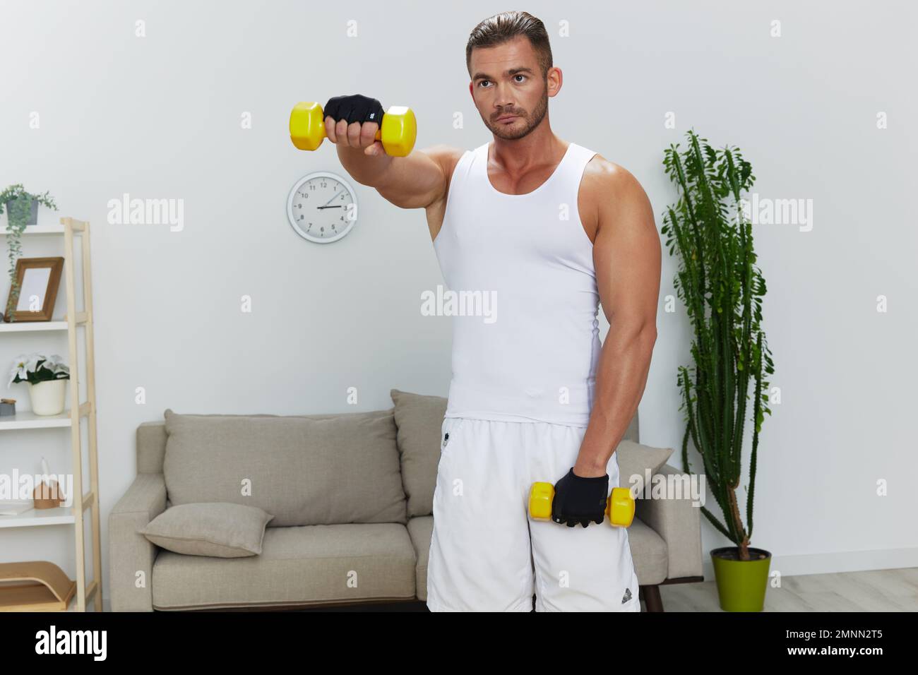 Man sports home training on the floor on a mat with dumbbells ...