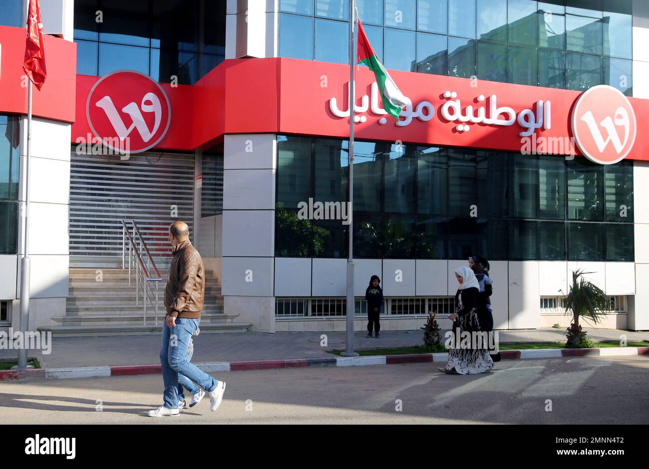 Residents pass by close offices of a Qatari-Palestinian cellular ...