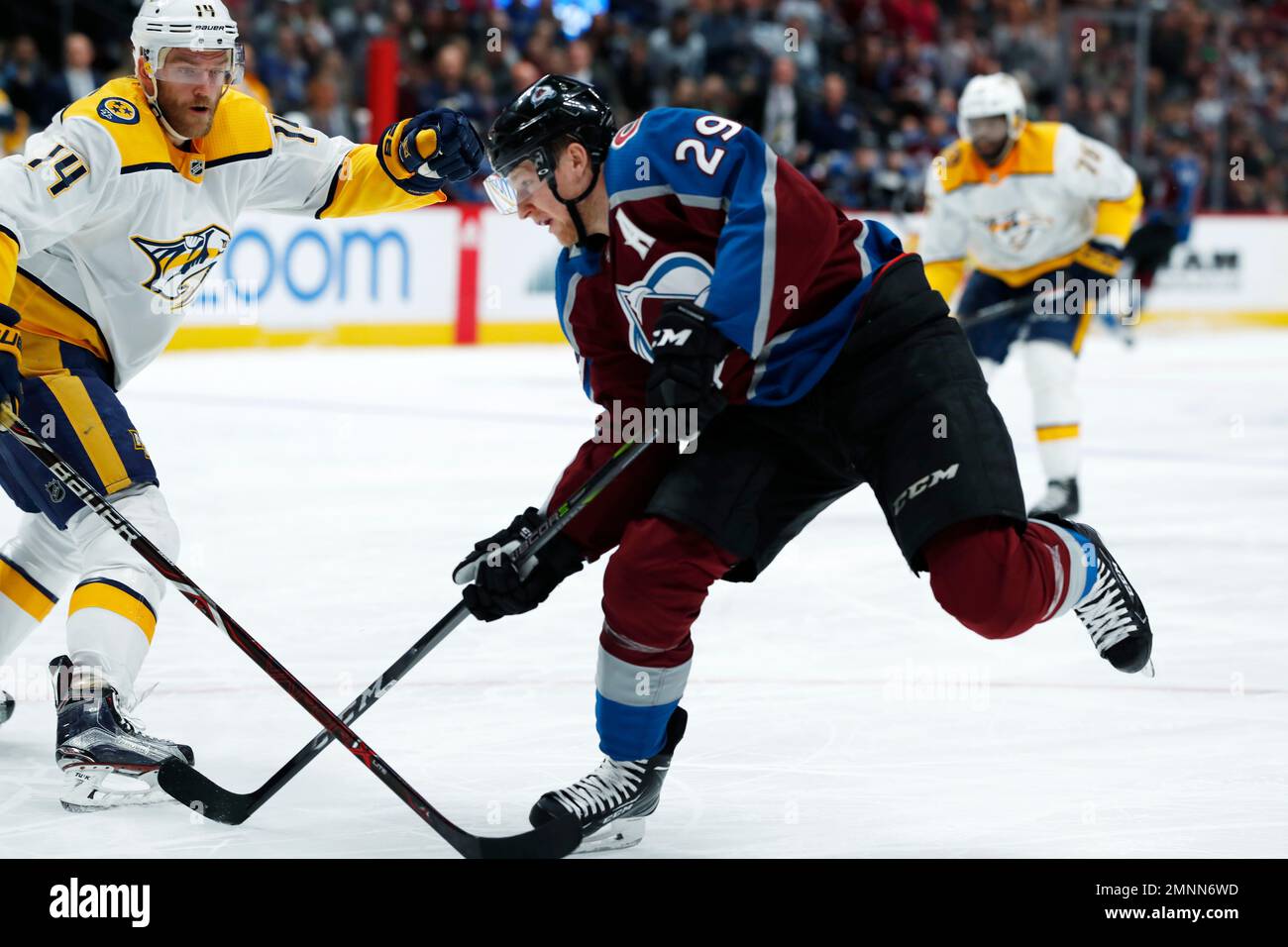 Colorado Avalanche center Nathan MacKinnon, front, fires the puck past ...
