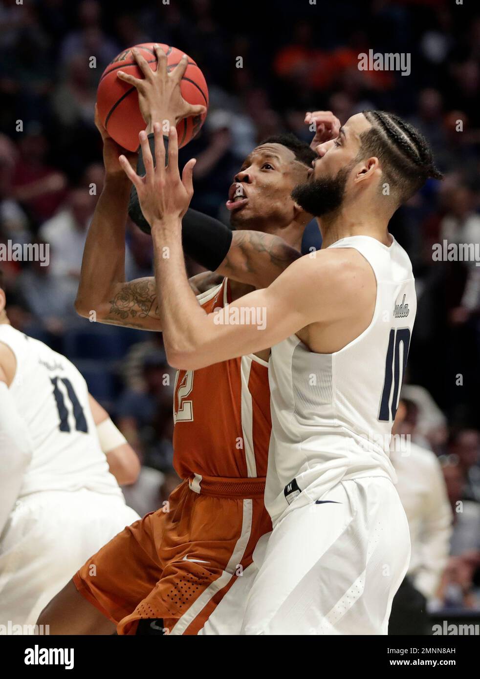 Texas guard Kerwin Roach II goes to the basket against Nevada forward ...