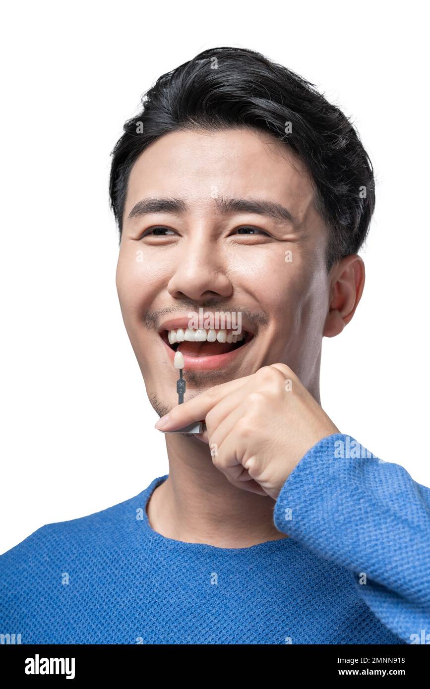 The young man holding a false teeth Stock Photo - Alamy