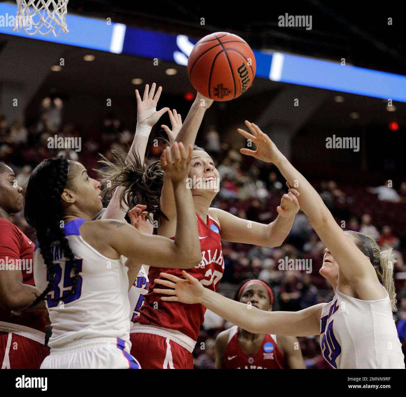 Oklahoma's Maddie Manning, center, reaches for a rebound between DePaul ...