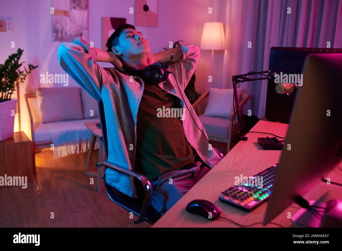 Tired teenage boy stretching back and leaning back in his chair after ...