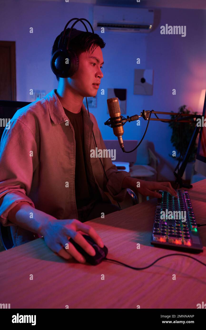 Videoblogger speaking in microphone when and playing on computer in ...