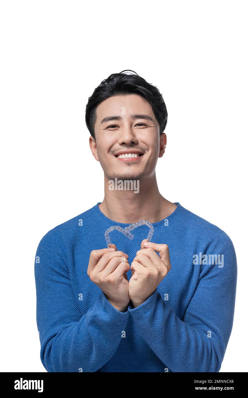 The young man holding a transparent braces Stock Photo - Alamy