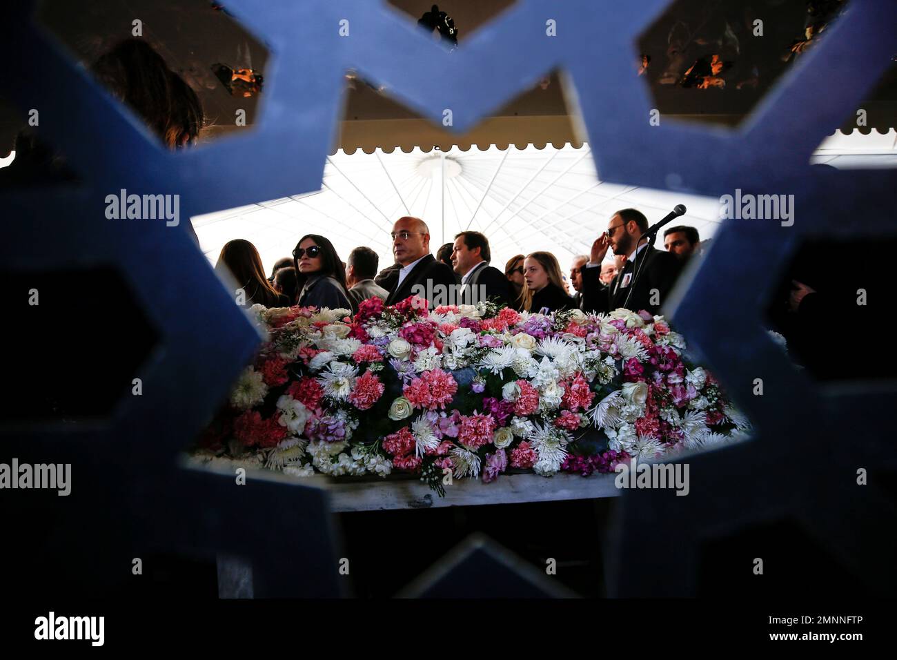 People gather around flower-covered coffin of Mina Basaran during ...