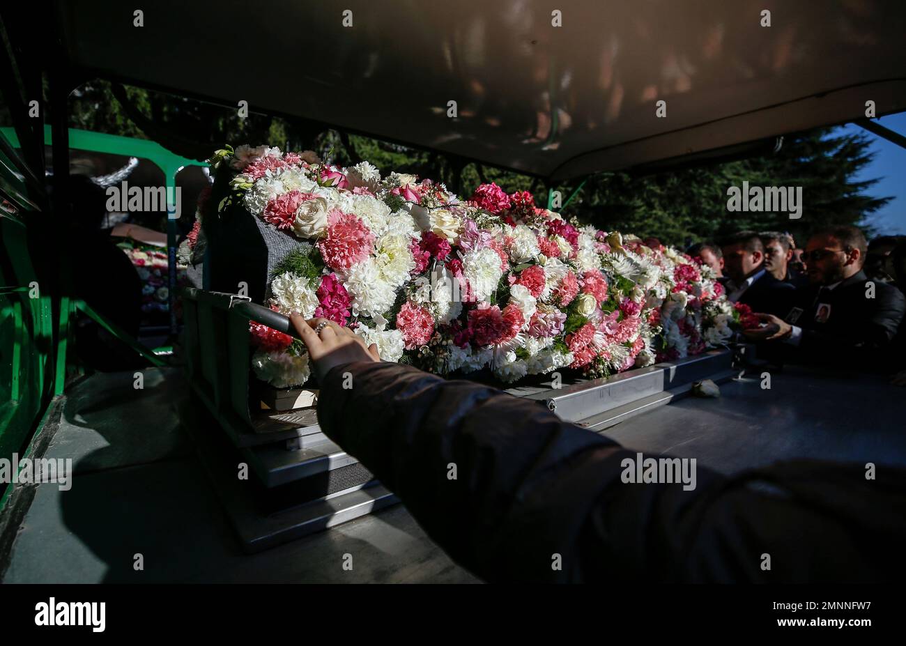 People gather around flower-covered coffin of Mina Basaran during ...