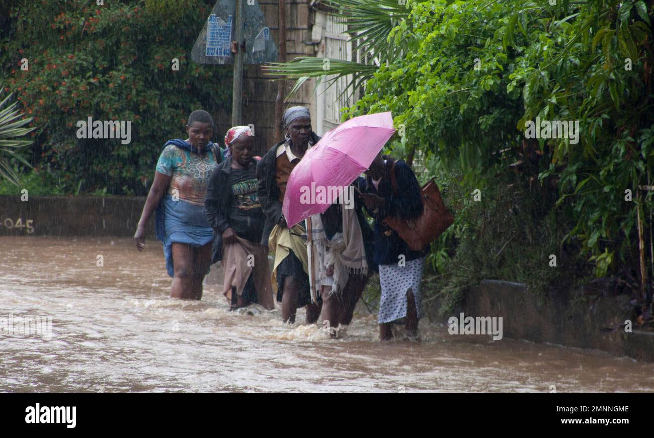 Kenyans pass through a flooded road in Nairobi, Thursday, March 15 ...