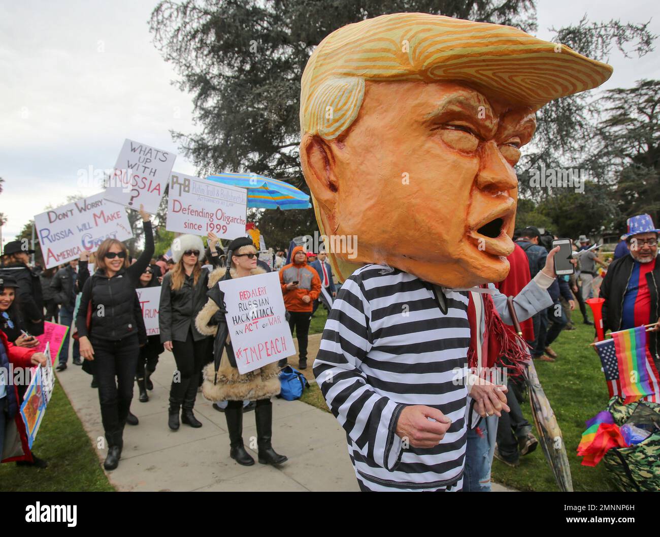 A protester wears a paper mache head of President Donald Trump during a ...