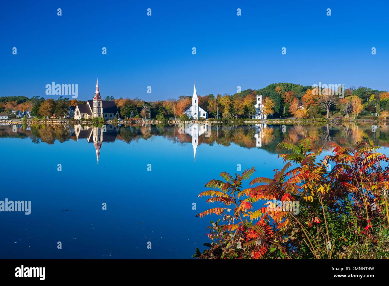 Reflections of churches with fall foliage color in Mahone Bay, Nova ...