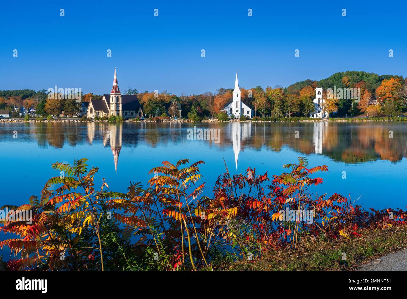 Reflections of churches with fall foliage color in Mahone Bay, Nova ...