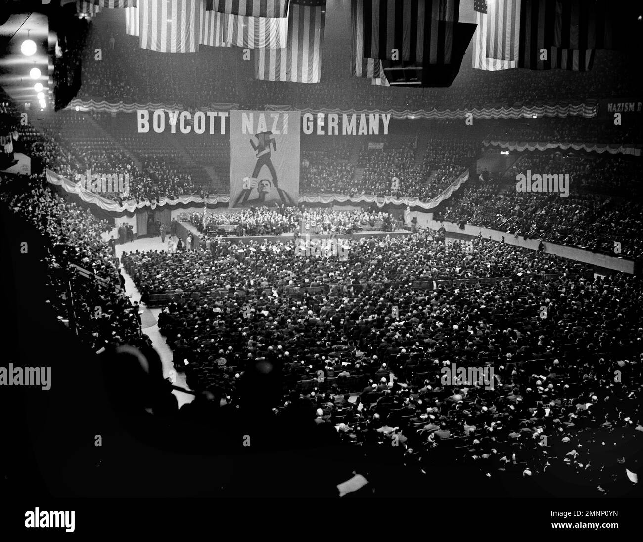 A sign advising people to "Boycott Nazi Germany" hangs behind the stage ...