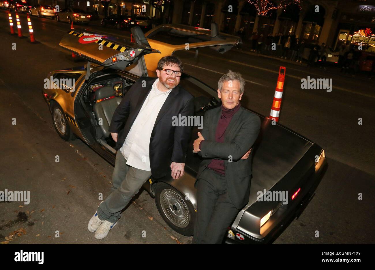 Ernie Cline, left, and Ben Mendelsohn sit on a DeLorean after arriving ...