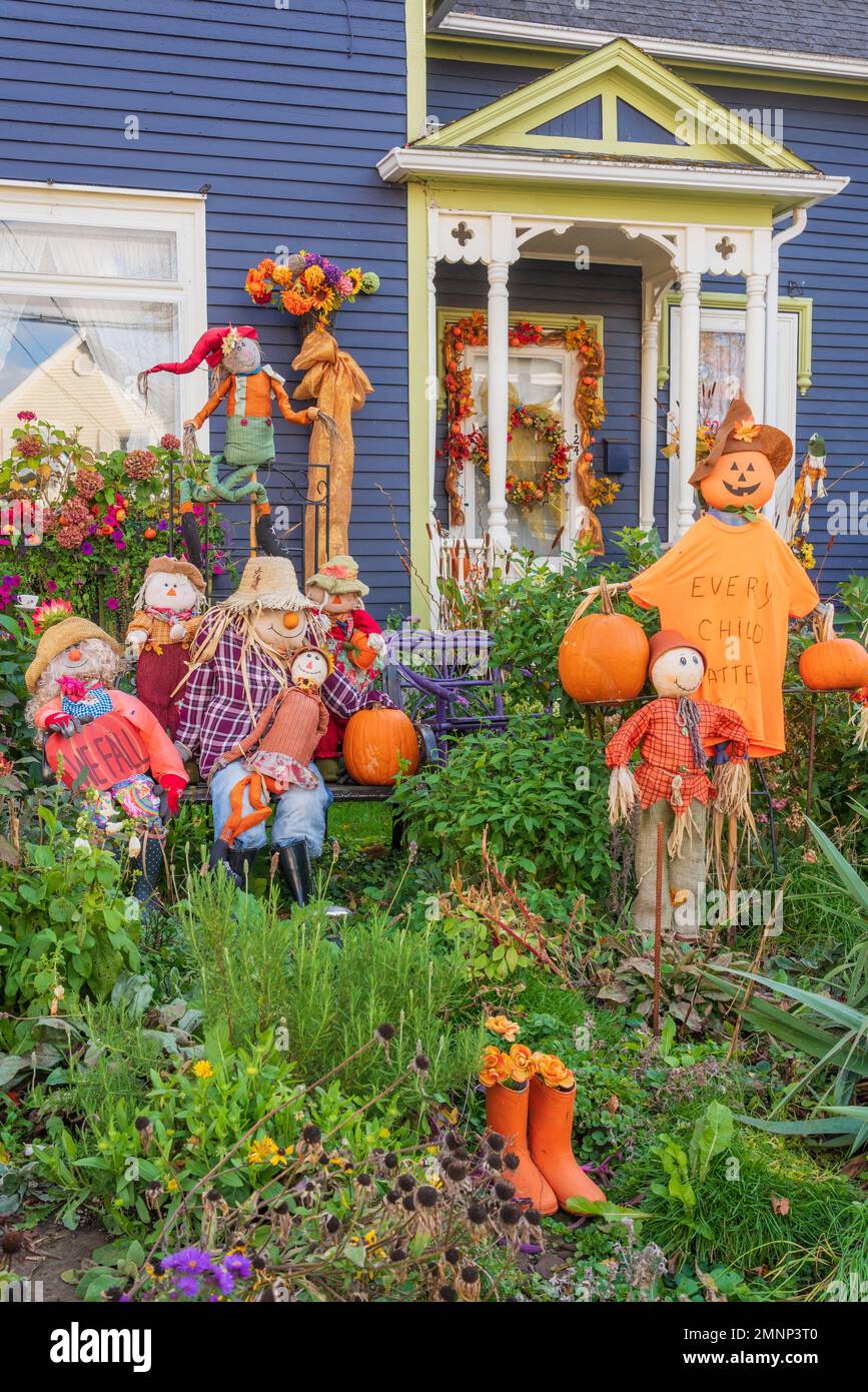 A pumpkin and scarecrow display in the front yard of a home in Truro ...