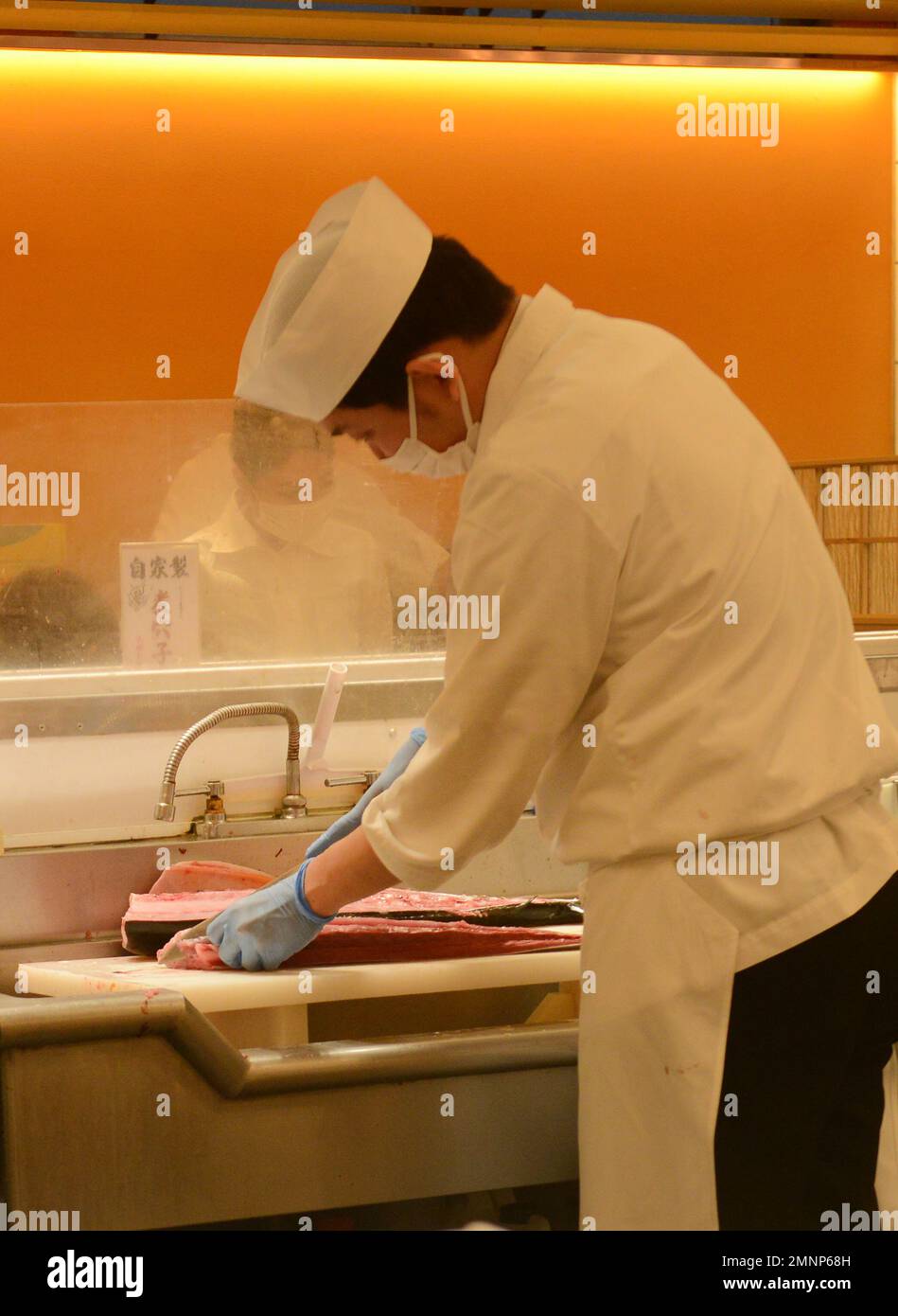 Sushi chef filleting a fresh Tuna fish at the Kaiten Sushi restaurant ...
