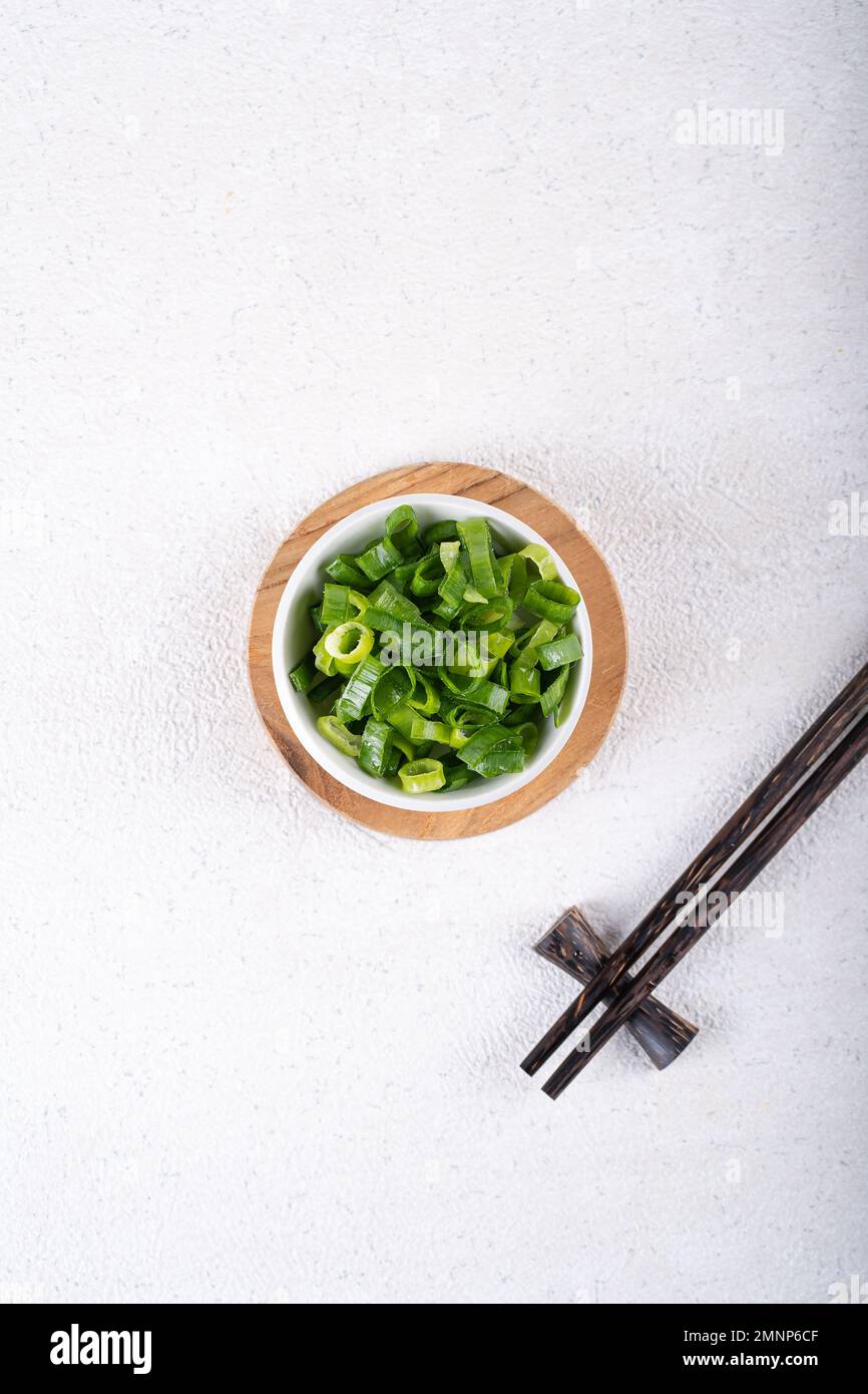Chopped spring onion in white bowl on white concrete. Ingredients food ...