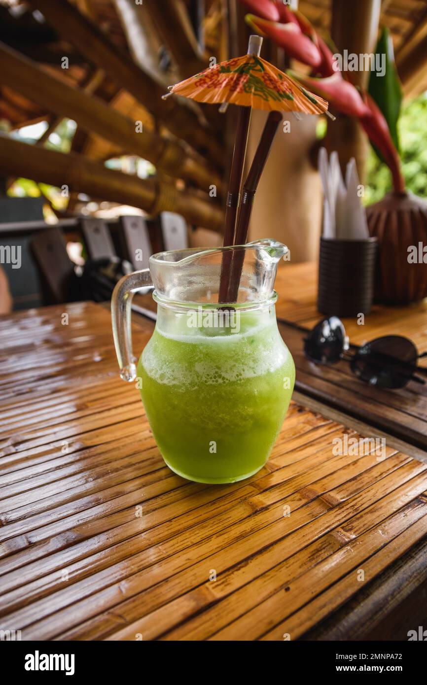 green tropical drink in glass pitchers on a restaurant table in ...