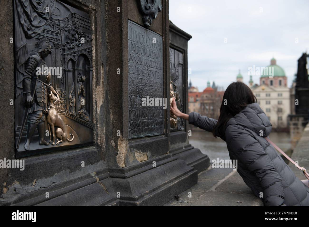 Woman touching religious icon of bronze bas-relief of King Wenceslas ...