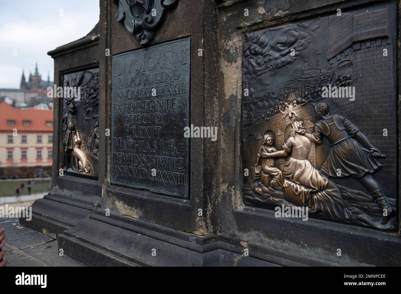 Religious icon of bronze relief under statue of St John of Nepomuk ...