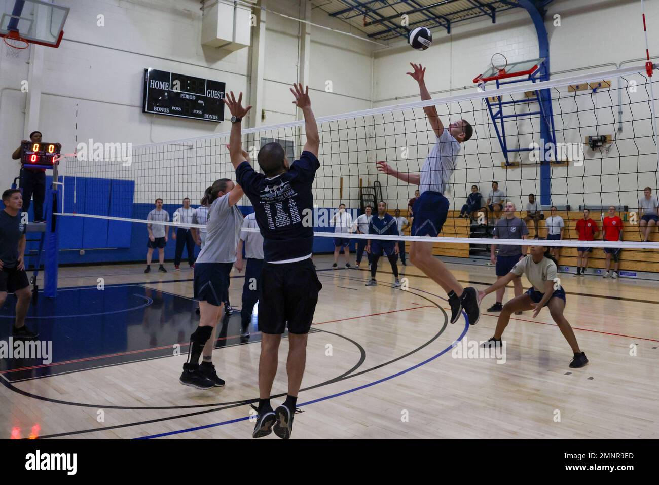 Airmen make a play on the ball during a volleyball match between the ...