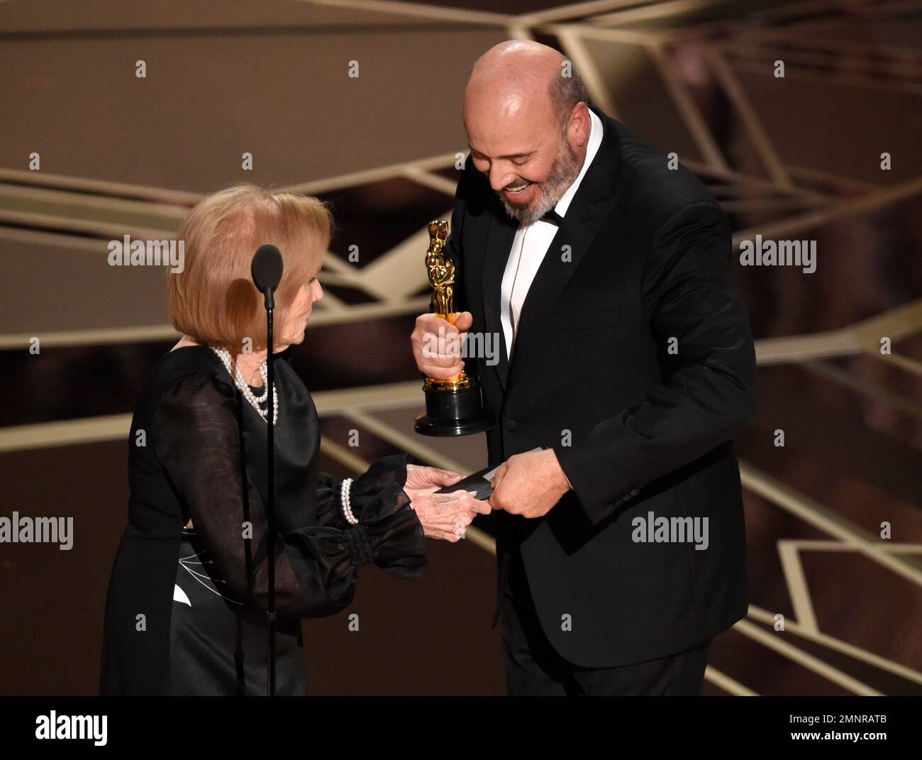 Eva Marie Saint, left, presents Mark Bridges with the award for best ...