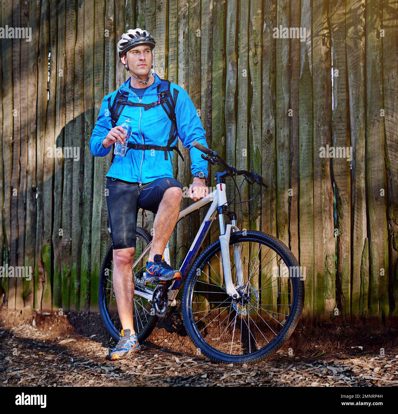 Working out in the woods. a male cyclist stopping for a water break ...
