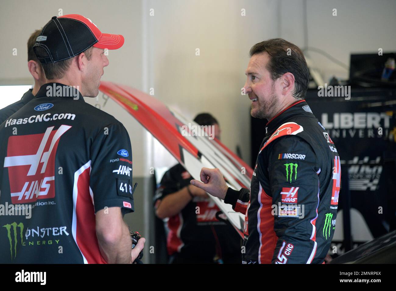 Kurt Busch, right, talks to crew members in the garage during practice ...