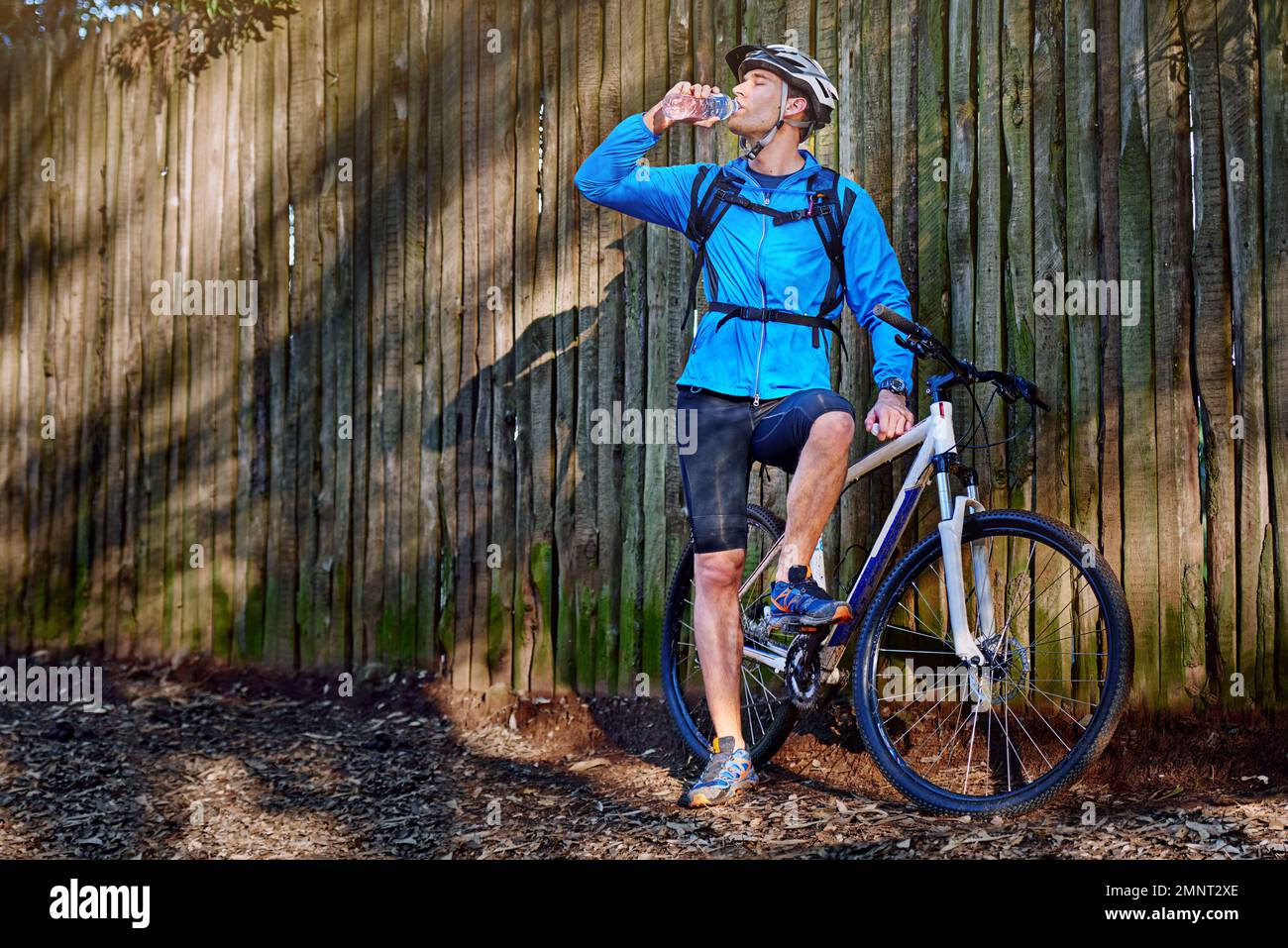 Working out in the woods. a male cyclist stopping for a water break ...