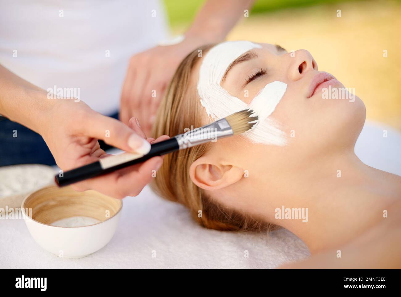 Her skin is getting a brush with greatness. a young woman getting a ...