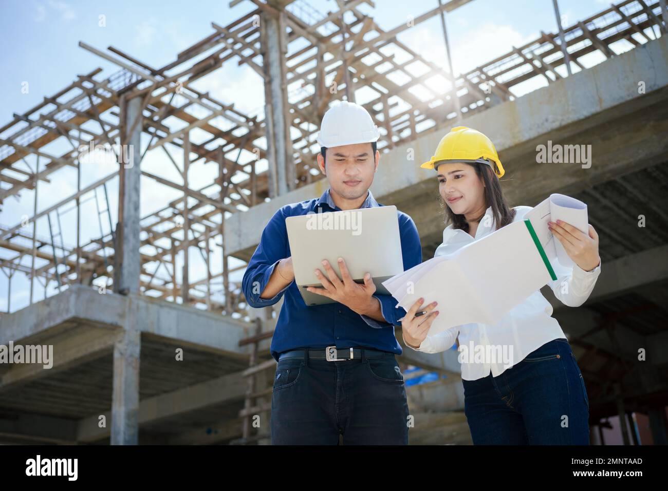 Asian Architector and engineers team with draft plan of building and ...