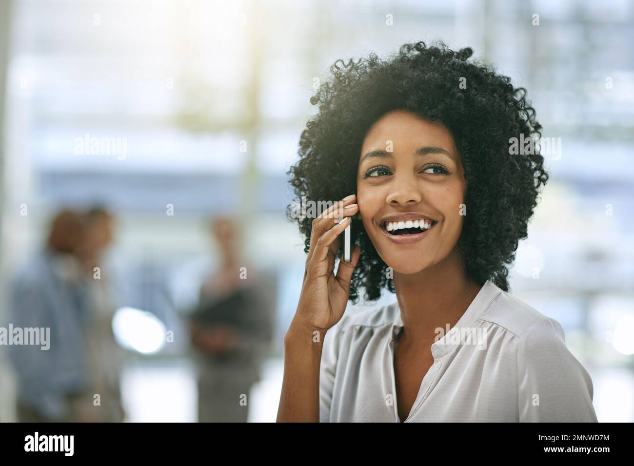 Getting some positive news. a young businesswoman using making a call ...