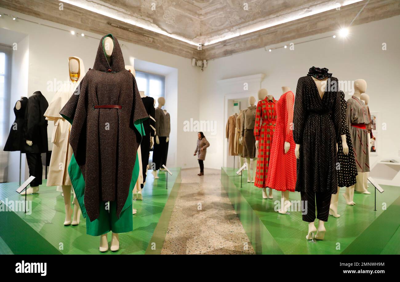 A woman takes pictures to designer clothes displayed at the exhibit ...