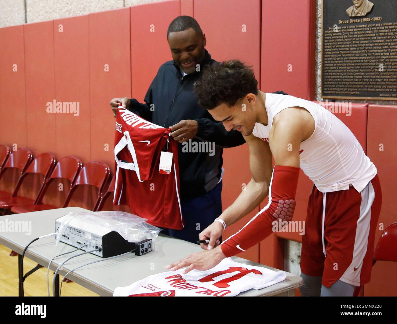 Oklahoma guard Trae Young autographs jersey under the watchful eye of ...