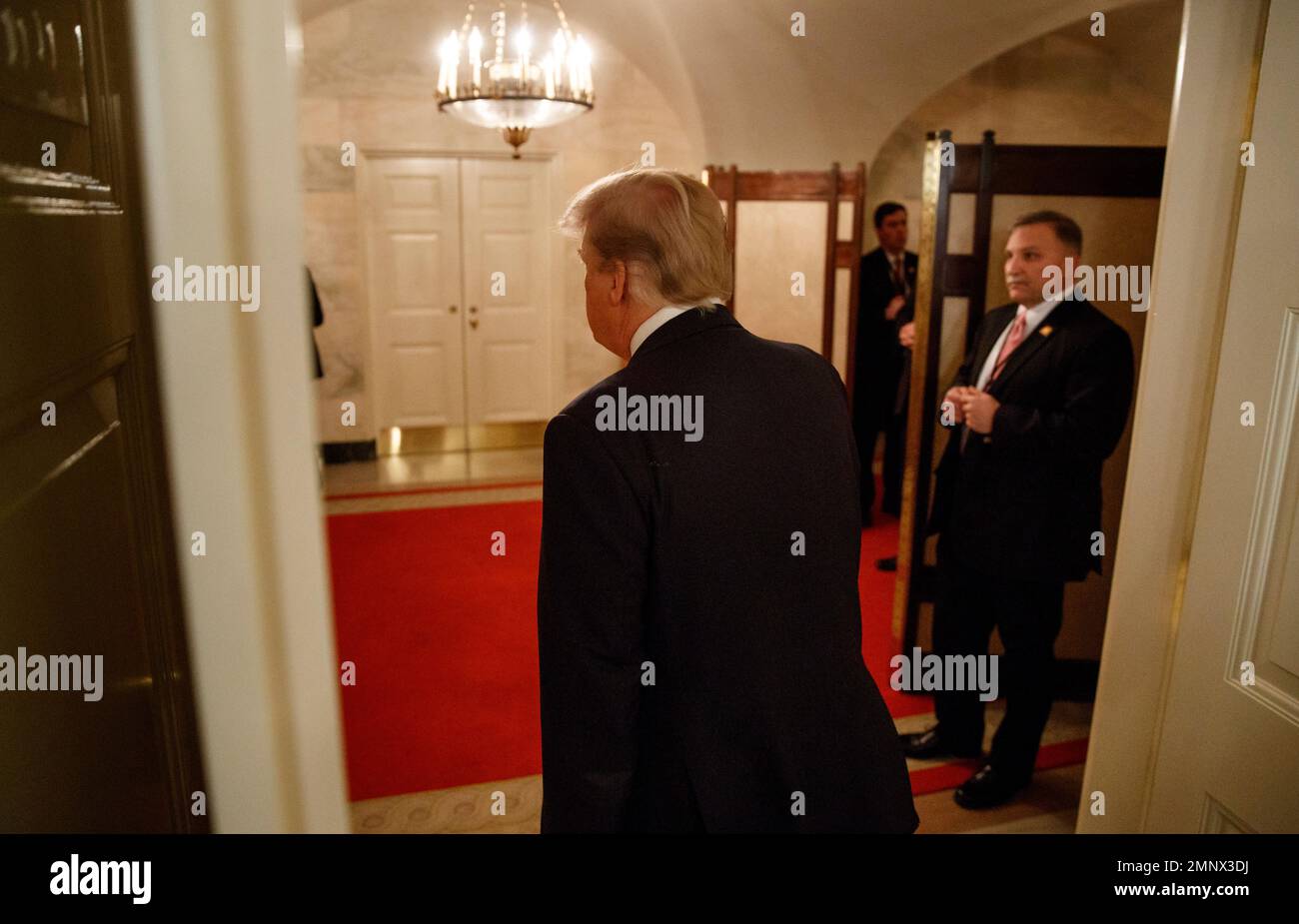 President Donald Trump walks from the Diplomatic Room of the White ...