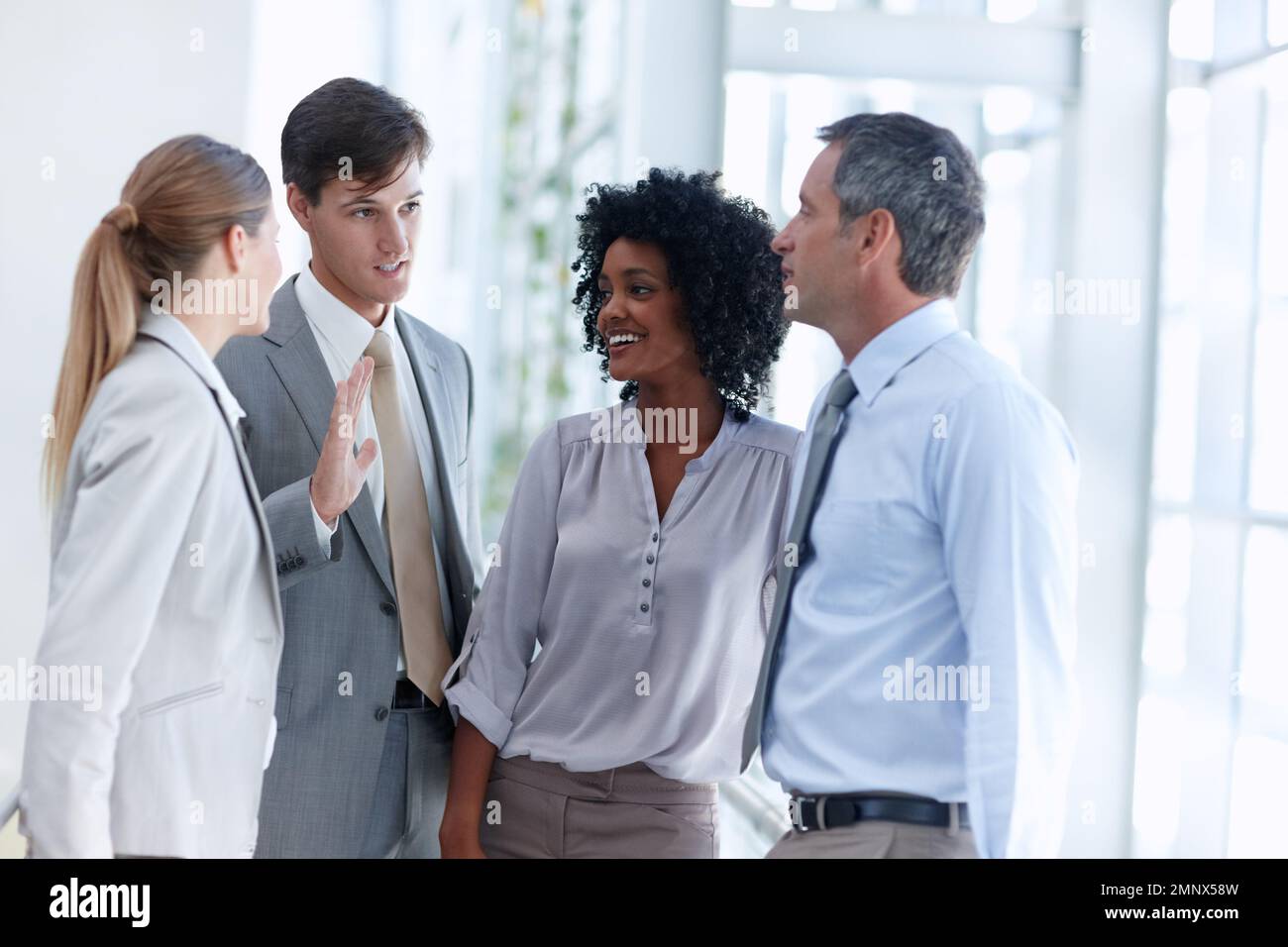 Office gossip. Four business colleagues catch up on office gossip Stock ...