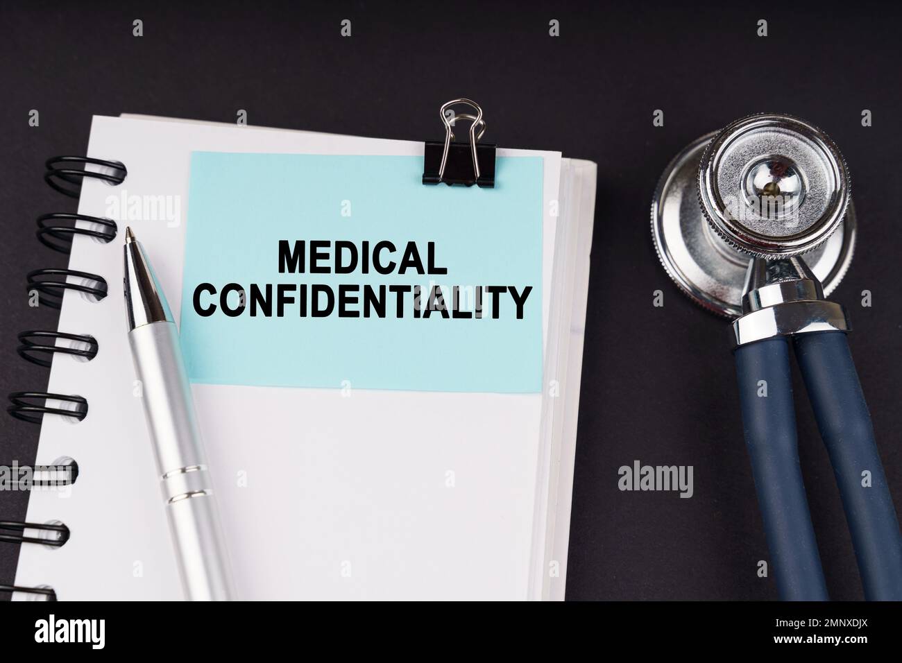 Medical concept. On a black surface, a stethoscope, a notebook, a pen ...