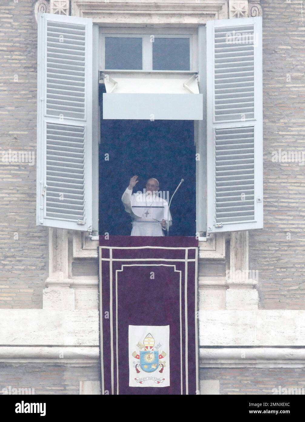 Pope Francis waves to faithful as he recites the Angelus noon prayer ...