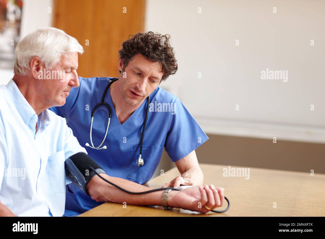 Monitoring his patients blood pressure. a doctor checking a senior ...
