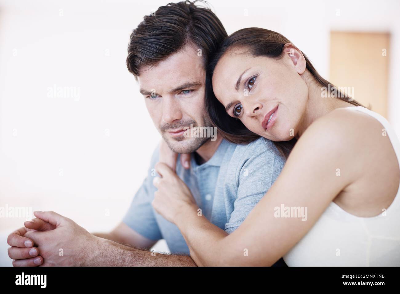 Its going to be okay...A woman embracing her husband as he sits beside ...