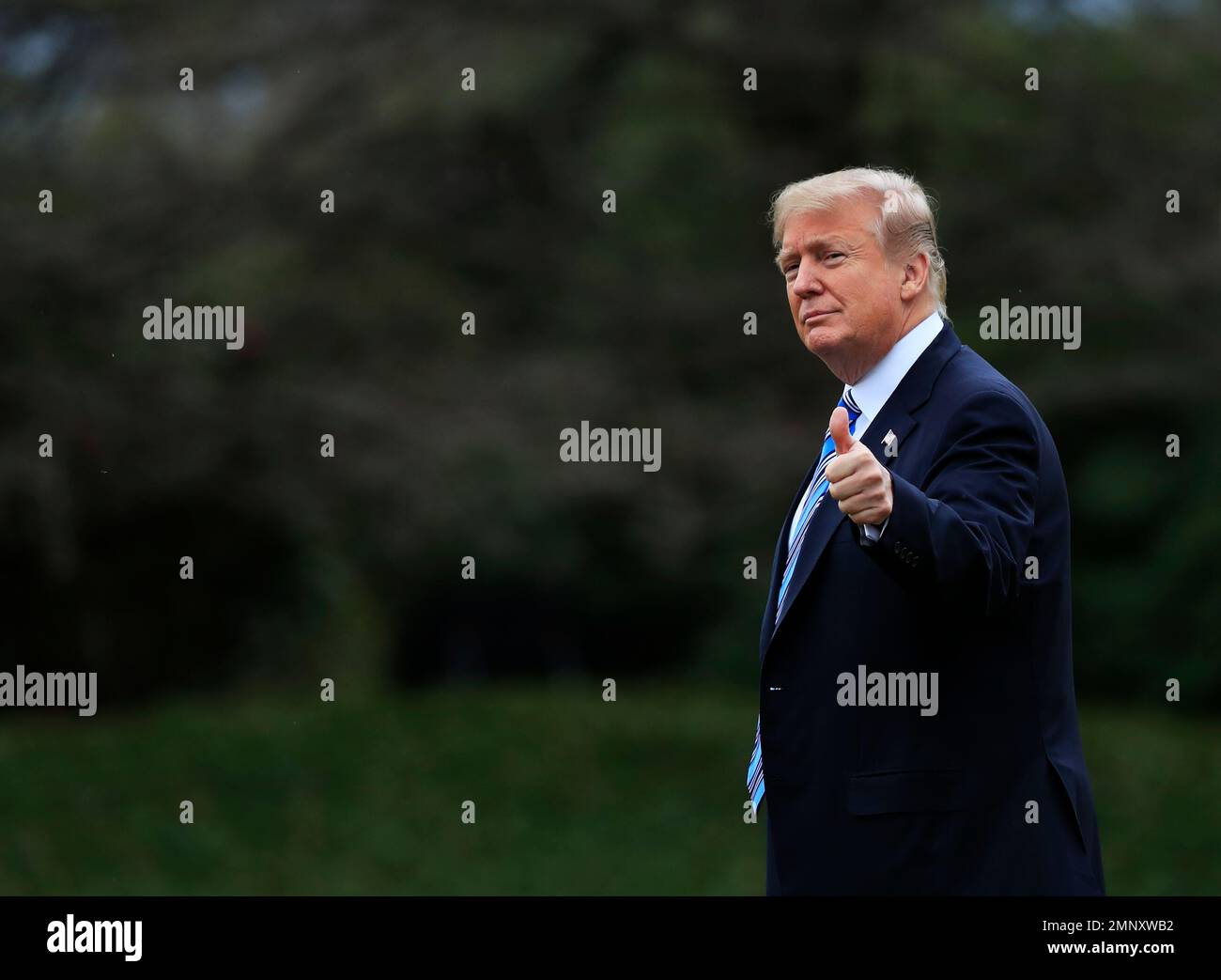 President Donald Trump flashes a thumbs up as he leaves the White House ...