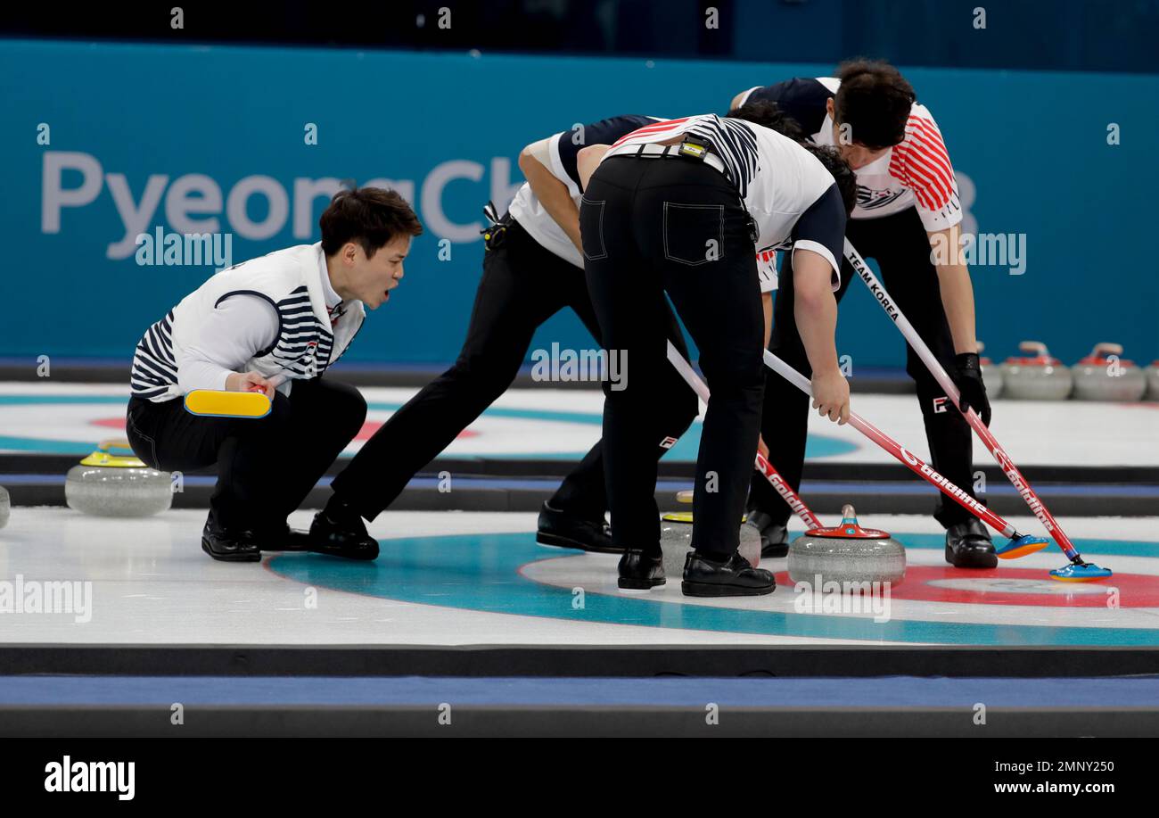 South Korea's skip Kim Changmin, left, watches his teammates sweep the ...