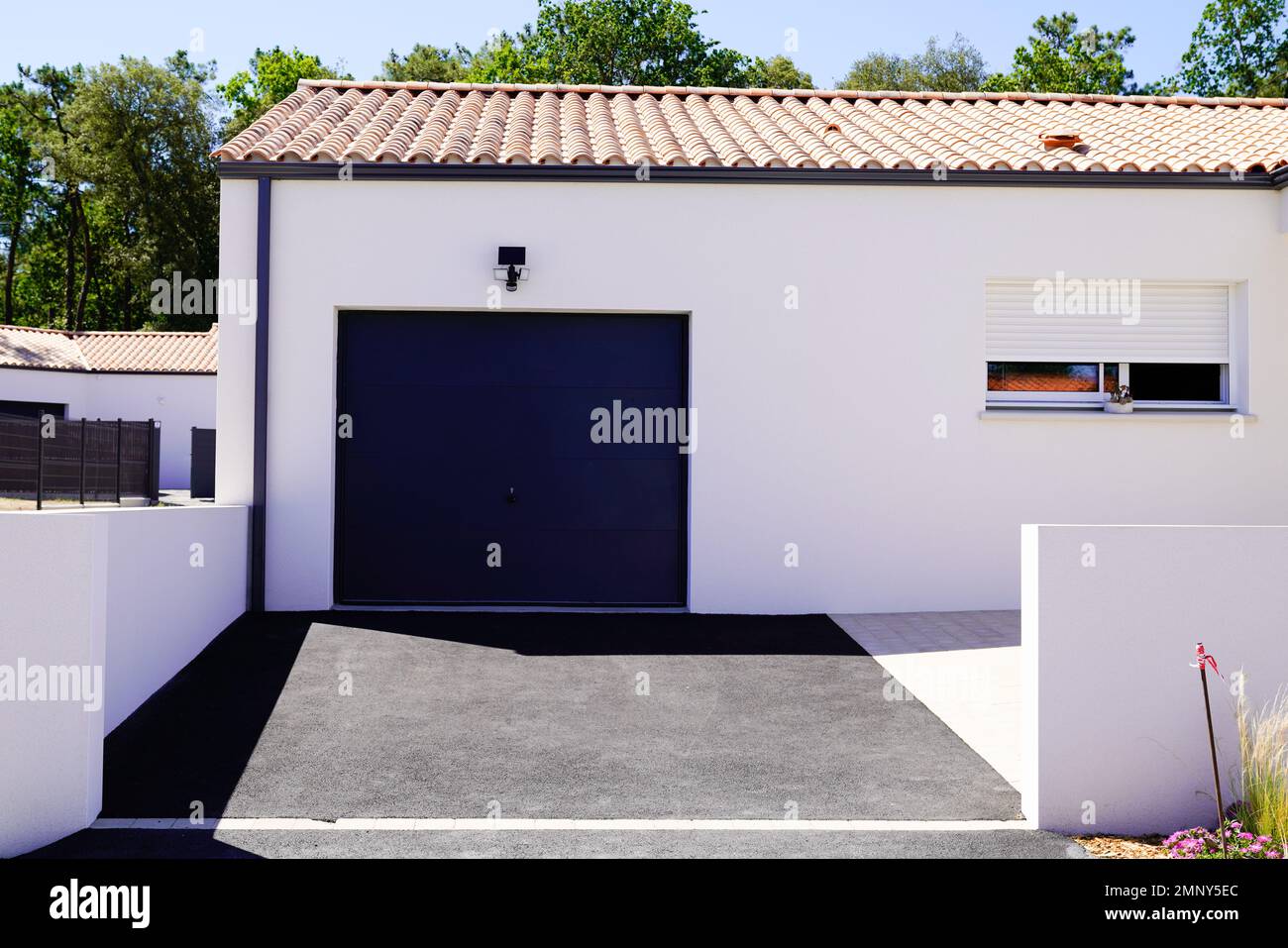 modern white house with black garage door without gate portal of suburb ...